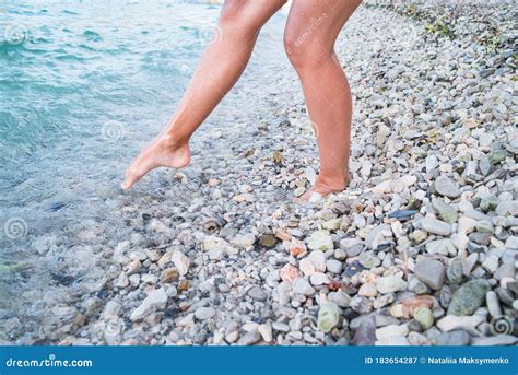 A Girl With Bare Feet Is Walking Along A Rocky Beach A Girl At The Sea