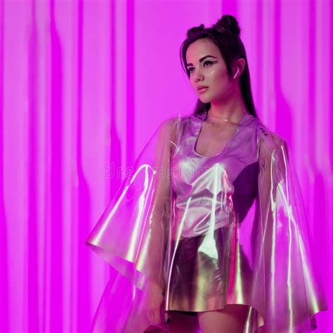 Cyberpunk Und Neon Ein Junges Trendmädchen in Einem Transparenten Latex Regenmantel Stockbild