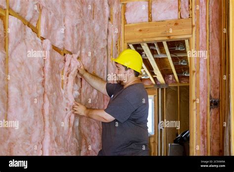 Man Installing Thermal Insulation Layer Under The Wall Using Mineral