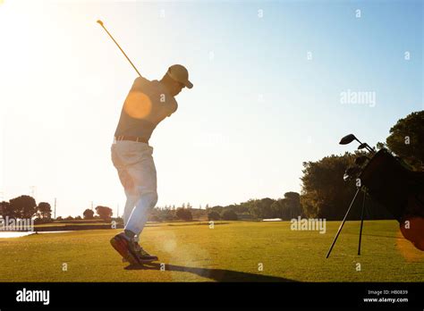 Golf Player Hitting Shot With Club On Course At Beautiful Morning With