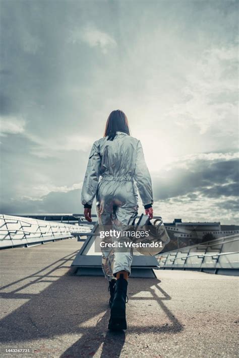 Astronaut Wearing Space Suit Holding Helmet Walking On Footpath High