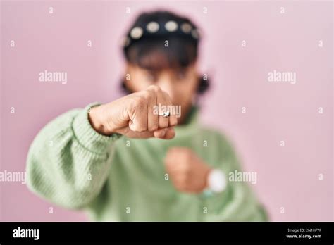 Young Beautiful Woman Standing Over Pink Background Punching Fist To