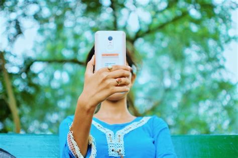 Premium Photo Woman Using Mobile Phone Against Trees