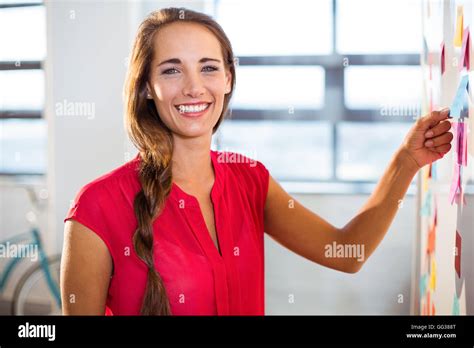 Woman Putting Sticky Notes On Whiteboard Stock Photo Alamy