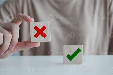 kvinna hand plocka fel eller korsa ikon på trä kub och kolla upp mark