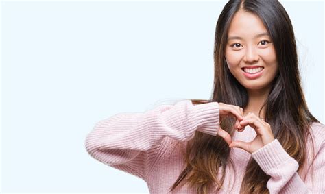 심장 기호와 손으로 모양을 보여주는 사랑에 웃 고 고립 된 배경 위에 젊은 아시아 여자 낭만적인 개념입니다 개념에 대한 스톡
