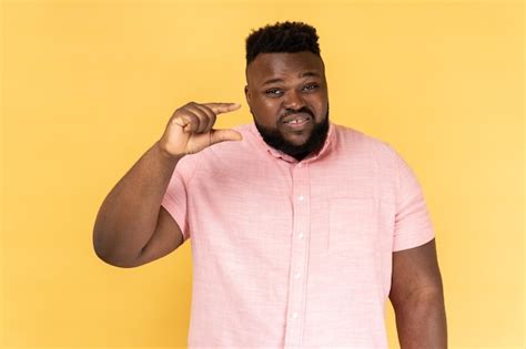 Premium Photo Man Showing A Little Bit Gesture And Smirking At Camera Measuring Size Need More