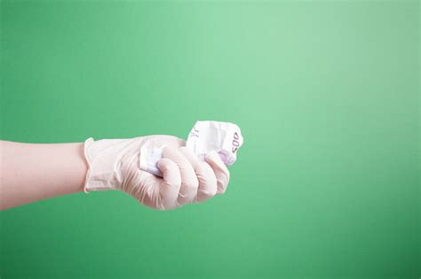 고무 흰색 의료 일회용 장갑에 여성 손은 구겨진 500 유로 지폐 녹색 배경 복사 공간을 보유하고 격리에 대한 스톡 사진 및