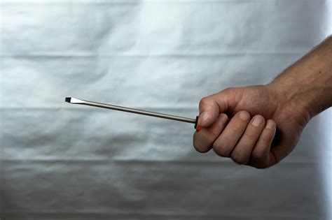 남자는 그의 손에 드라이버를 들고있다 나사를 나사로 조이기 위한 시공 도구 Diy에 대한 스톡 사진 및 기타 이미지 Diy