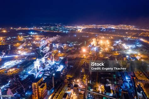 밤에는 연무판과 불이 파이프에서 솟아오르는 강철 공장의 공중 보기 야금 생산의 폭발적인 분노와 산업 파노라마 랜드 마크 환경오염의 개념 밤 하루 시간대에 대한 스톡 사진 및