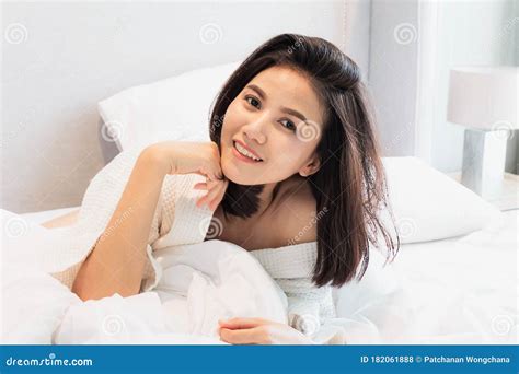 Young Beautiful Asian Woman Wore White Bathrobe Lying On Bedrelax In