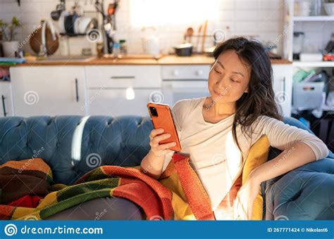 Young Asian Woman Relax On Comfortable Couch At Home Texting Messaging