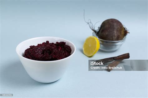 사탕무 레몬 계피 스틱이 있는 흰색 그릇에 담긴 천연 사탕무 잼이 파란색 배경에 붙어 있습니다 0명에 대한 스톡 사진 및 기타