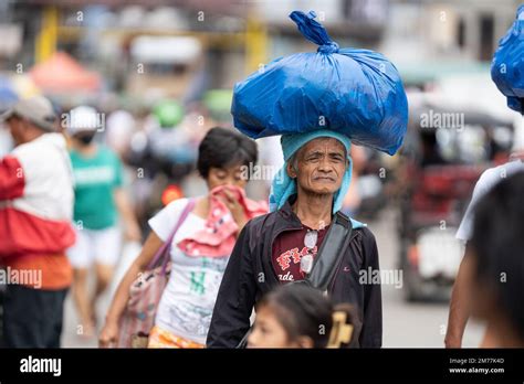 A Man Transports A Bag With Contents On Top Of His Head A Traditional