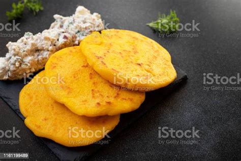 검은 접시에 치즈와 허브를 곁들인 갈은 옥수수 반죽의 라틴 아메리카 식 아침 식사 아레파스 베네수엘라와 콜롬비아의 요리 맨 위