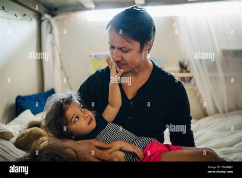 Mature Father And Playful Daughter Bonding While Sitting In Bedroom