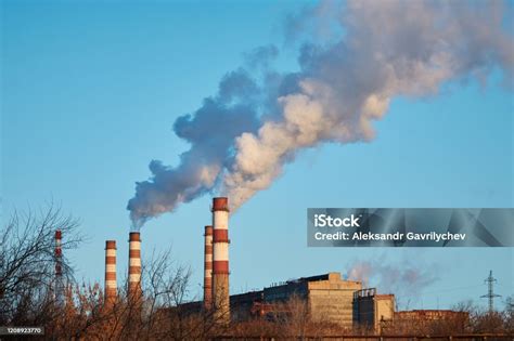 이 공장은 화창한 날에 파이프에서 연기와 스모그를 방출하고 오염 물질이 대기로 유입됩니다 0명에 대한 스톡 사진 및 기타 이미지