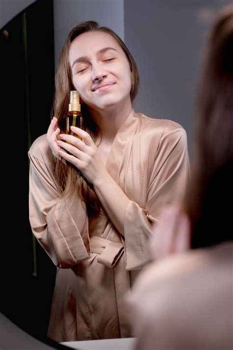 Young Woman Applying Natural Organic Essential Oil On Hair And Skin