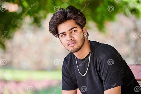 Attractive Indian Man Smoker Exhales Cigarette Smoke Portrait In Black