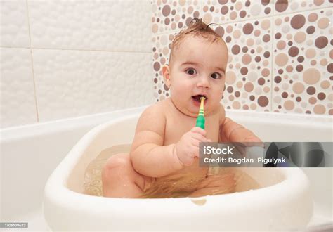 어린 아이가 욕조에서 목욕하고 있다 아기는 이빨을 닦습니다 가족의 행복 저녁 물 절차 신체 위생 6 11 개월에 대한 스톡 사진 및 기타 이미지 Istock