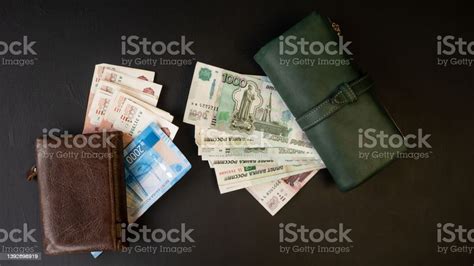 러시아 돈 지폐 5000 2000 1000 500 루블로 가득 찬 녹색과 갈색 지갑의 클로즈업 검은 배경 남성과 여성의 지갑 0