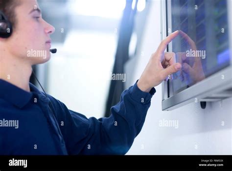 Low Angle Side View Of Young Man Wearing Headset Using Touch Screen
