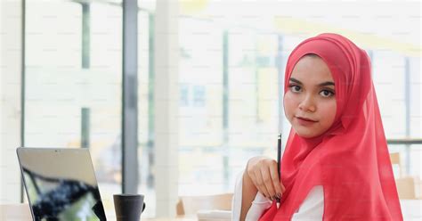 초상화가 테이블에 찍힌 카페에서 일하는 이슬람 여성 사진 Unsplash의 앉아 이미지