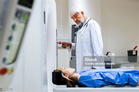 스캐너 침대를 놓는 환자에게 Mri 스캔 절차를 설명하는 선임 의사의 중간 샷 측면보기 아르헨티나에 대한 스톡 사진 및 기타