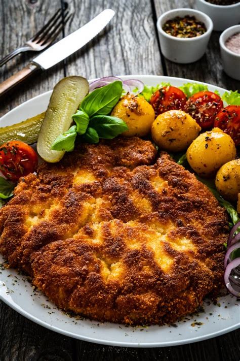 Breaded Seared Pork Chop With Fresh Vegetable Salad And Potatoes On
