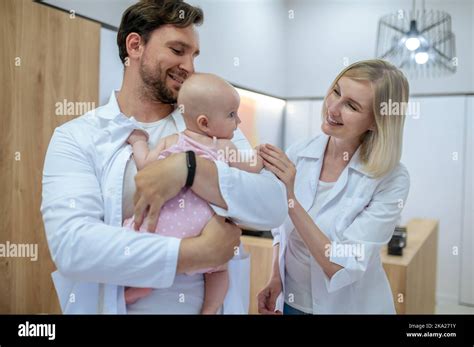 Experienced Pediatric Doctors Checking The Reflexes Of The Newborn