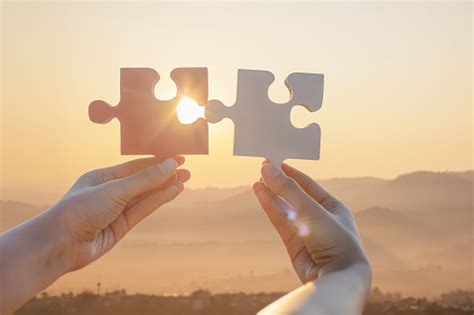 일몰 배경과 함께 커플 빨간색과 흰색 퍼즐 조각을 연결하려고하는 두 손 팀 지원 및 도움말 개념 협회와 연결의 상징 사업 전략 완료 2명에 대한 스톡 사진 및 기타 이미지