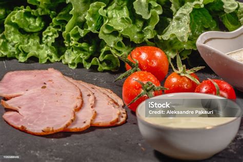 이탈리아어 브루스 케 타 요리에 대 한 재료는 어두운 테이블에 체리 토마토 치즈 소스 샐러드 잎 마늘 올리브 오일과 햄으로