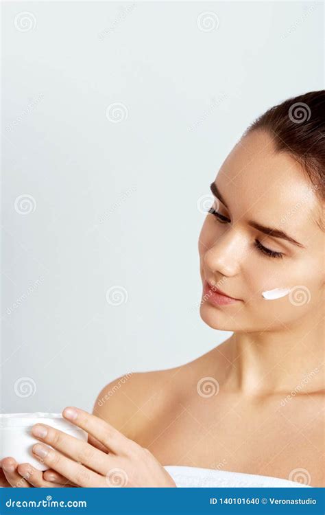 Concetto Di Cura Di Pelle Bella Crema Di Fronte Della Tenuta Della Donna In Mani Ritratto Del