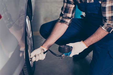 전문가 전문 기술자 하드웨어 자동 워크샵 흰 니트 장갑에 팔은 자동차의 타이어 물리적 압력 검사 자른 샷까지 가까운 전반적으로 특별 한 유니폼을 착용 검사 보기에 대한 스톡