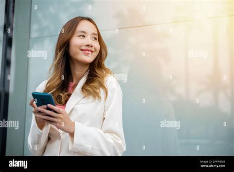 portrait successful business woman smiling holding smartphone using app