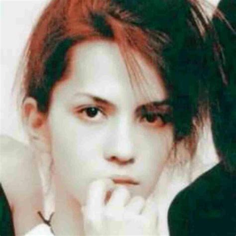 A Woman With Red Hair Is Posing For The Camera