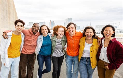 Happy Group Of Teen Friends Hugging Each Other Smiling At Camera