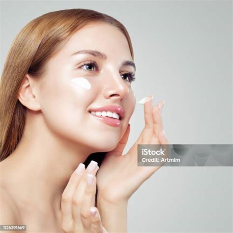 완벽 한 피부와 아름 다운 여자의 얼굴입니다 젊은 여자 Applyng 보습 크림입니다 아름다움 크림 스킨케어 및 얼굴 치료의