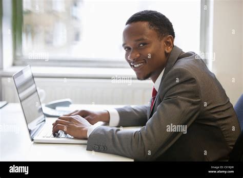 Portrait Of Happy African American Businessman Using Laptop At Office