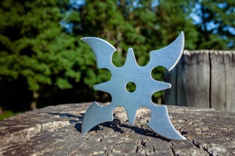 Shuriken 던지는 별 전통 일본 닌자 냉기 무기가 나무 배경에 붙어 있습니다 프리미엄 사진