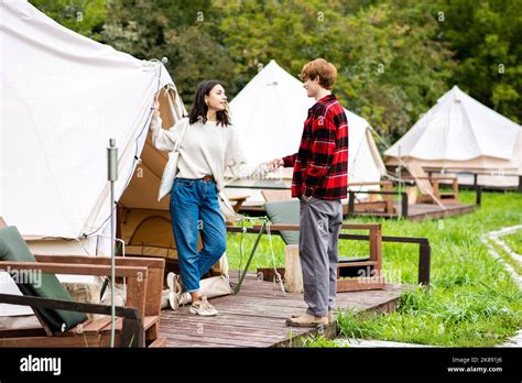 A Couple Talking And Entering A Tent At Glamping Lush Forest Around