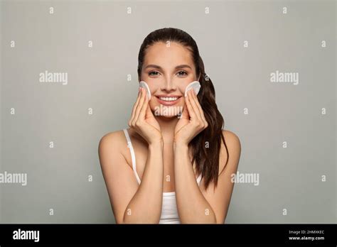Healthy Fresh Woman Removing Makeup From Her Face With Cotton Pads And