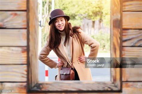 아름 다운 유행 장난 중국 아가씨 나무 창 전경 거리에 포즈의 야외 초상화 세련 된 모자 및 옷을 입고 모델입니다 화창한
