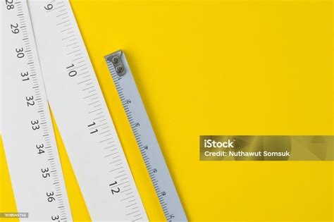 흰색 긴 테이프 복사 공간 길이와 선명한 노란색 배경에 인치와 센티미터를 측정 또는 메이커 개념 Diy에 대한 스톡 사진 및