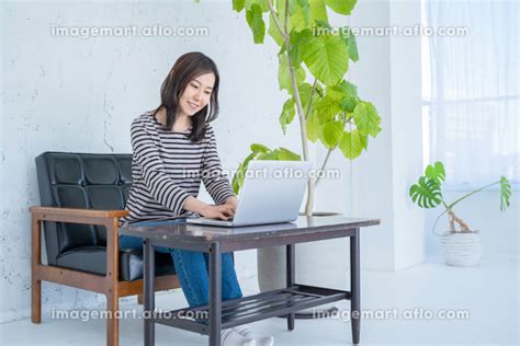 明るいリビングでソファに座りパソコン作業をする日本人女性 （人物）の写真素材 210271650 イメージマート