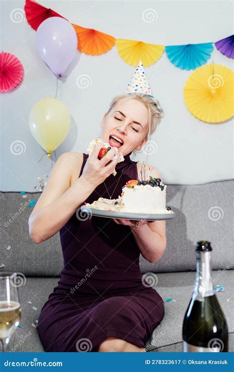 Woman In Festive Dress And Party Cap Eating Birthday Cake With Her
