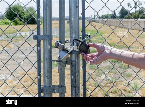 Women Unlocks One Of Three Locks On Gate Stock Photo Alamy
