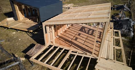 산에서 건설 중인 말뚝 기초 위에 있는 목조 프레임 하우스의 조감도 사진 Unsplash의 사업 이미지