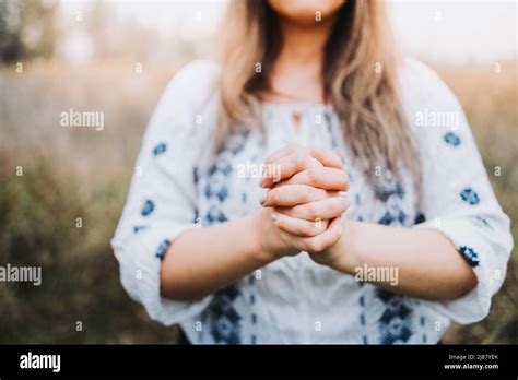 Unrecognizable Woman Outside Praying On Her Knees With Her Hands