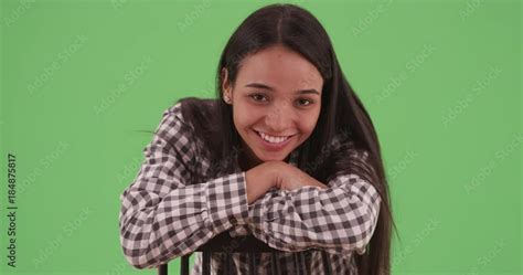 Smiling Hispanic Girl Sitting Backwards In Her Chair With Her Arms